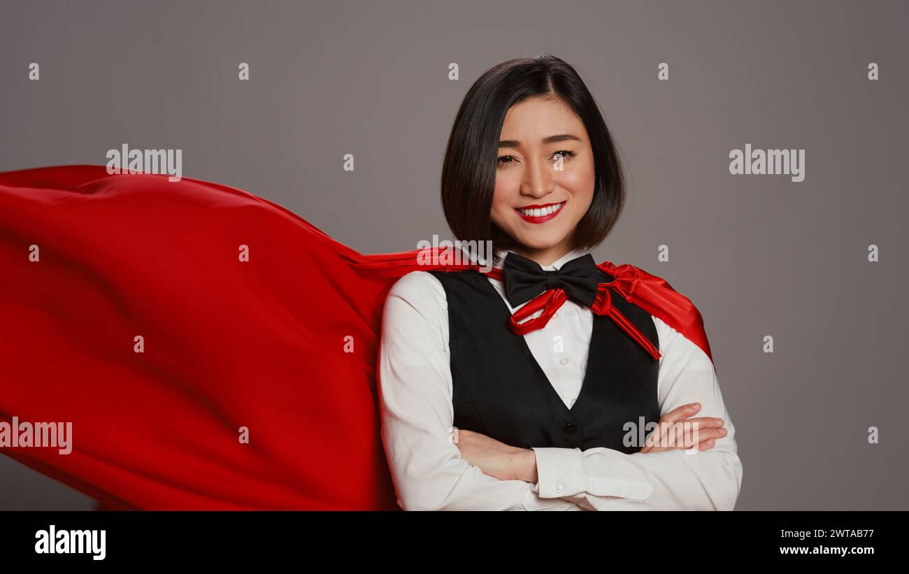 Asian receptionist posing with red superhero cape on camera, feeling ...