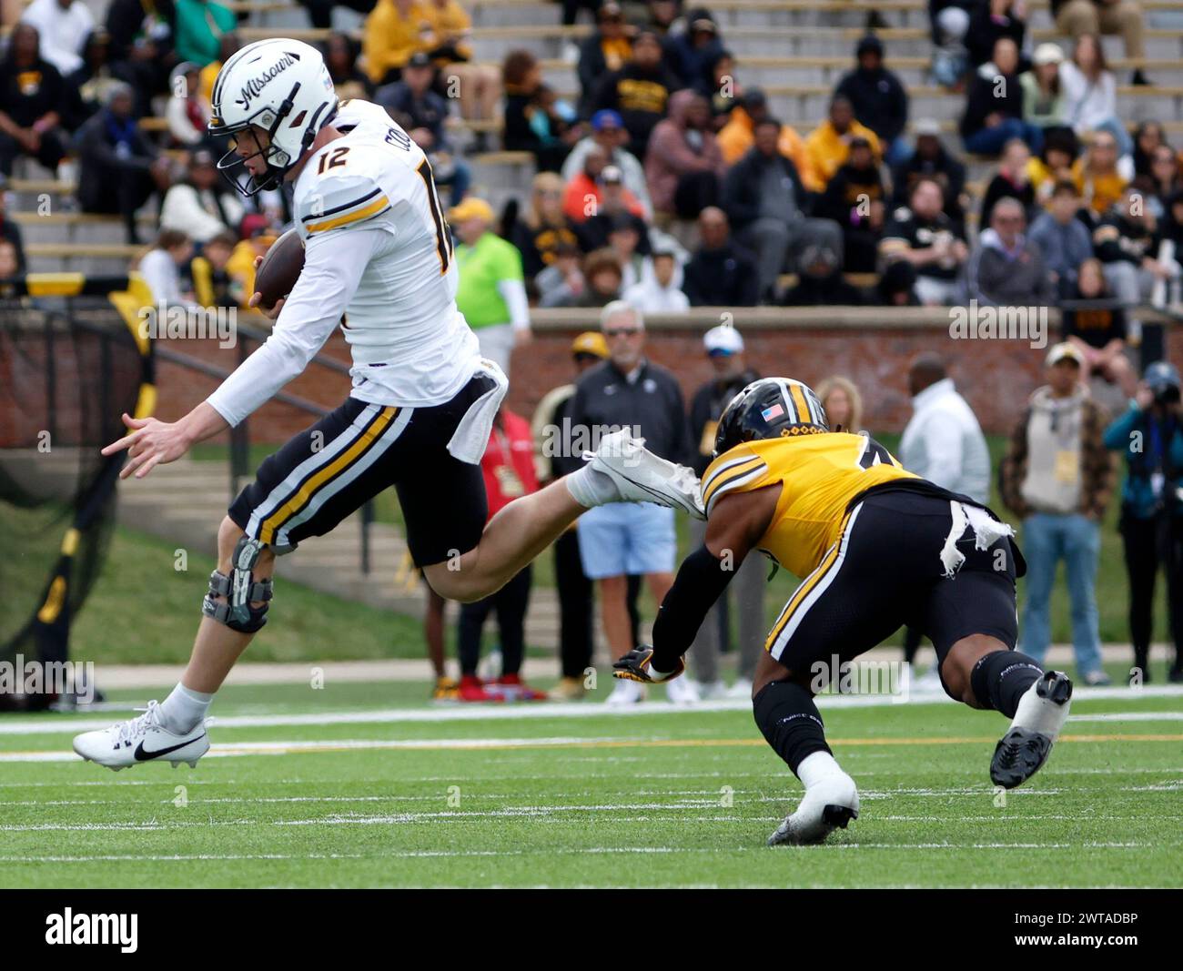 Missouri quarterback Brady Cook (12) jumps over defensive back Tre'Vez ...