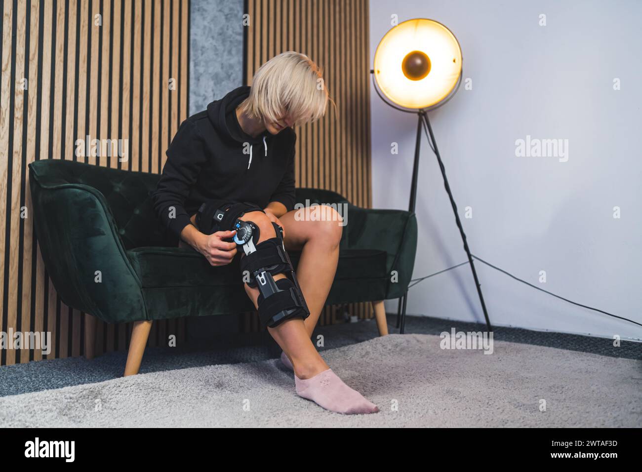 a caucasian woman fitting leg compression brace while sitting on the ...