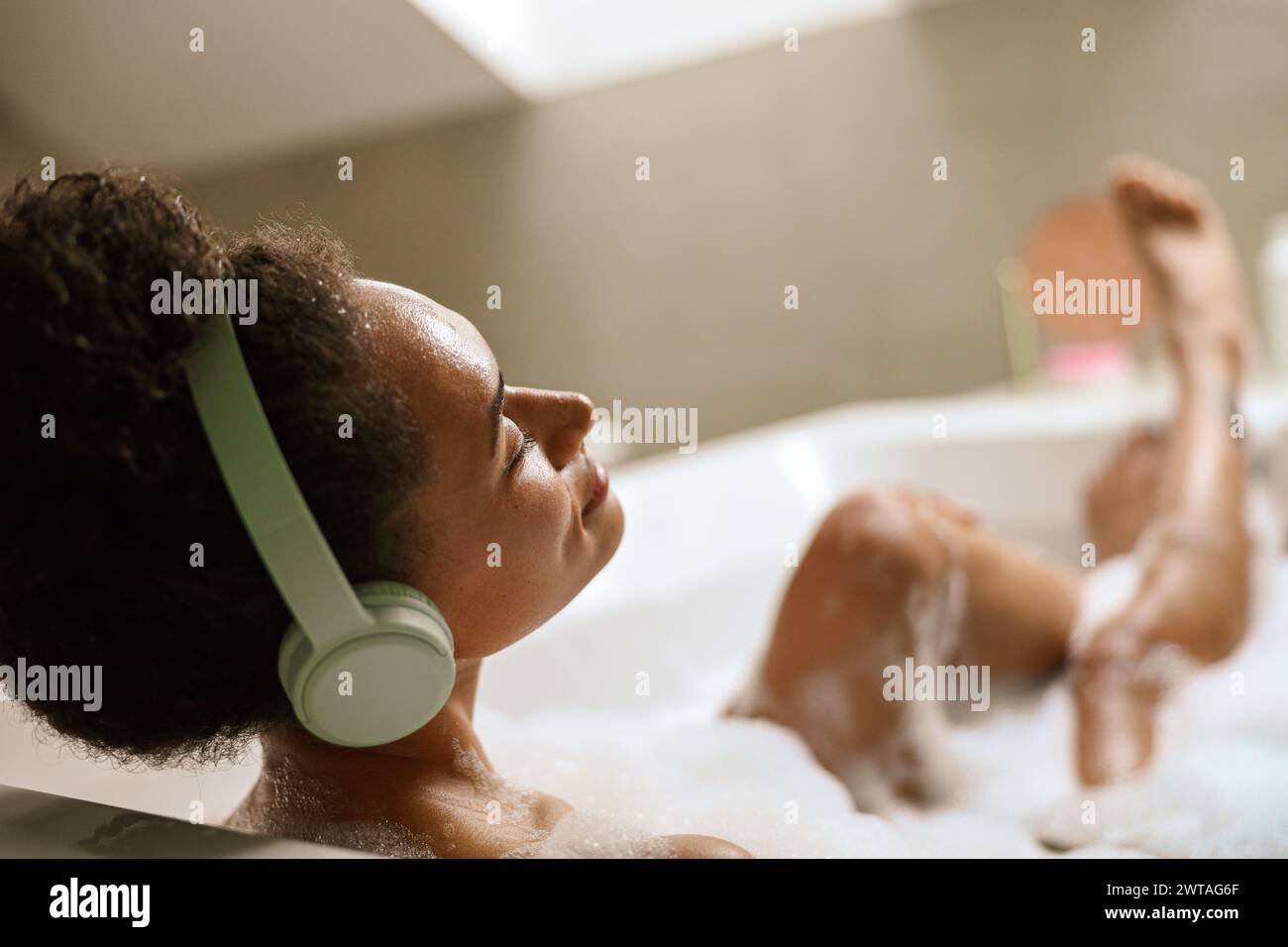 A woman is listening to music in a bathtub Stock Photo - Alamy
