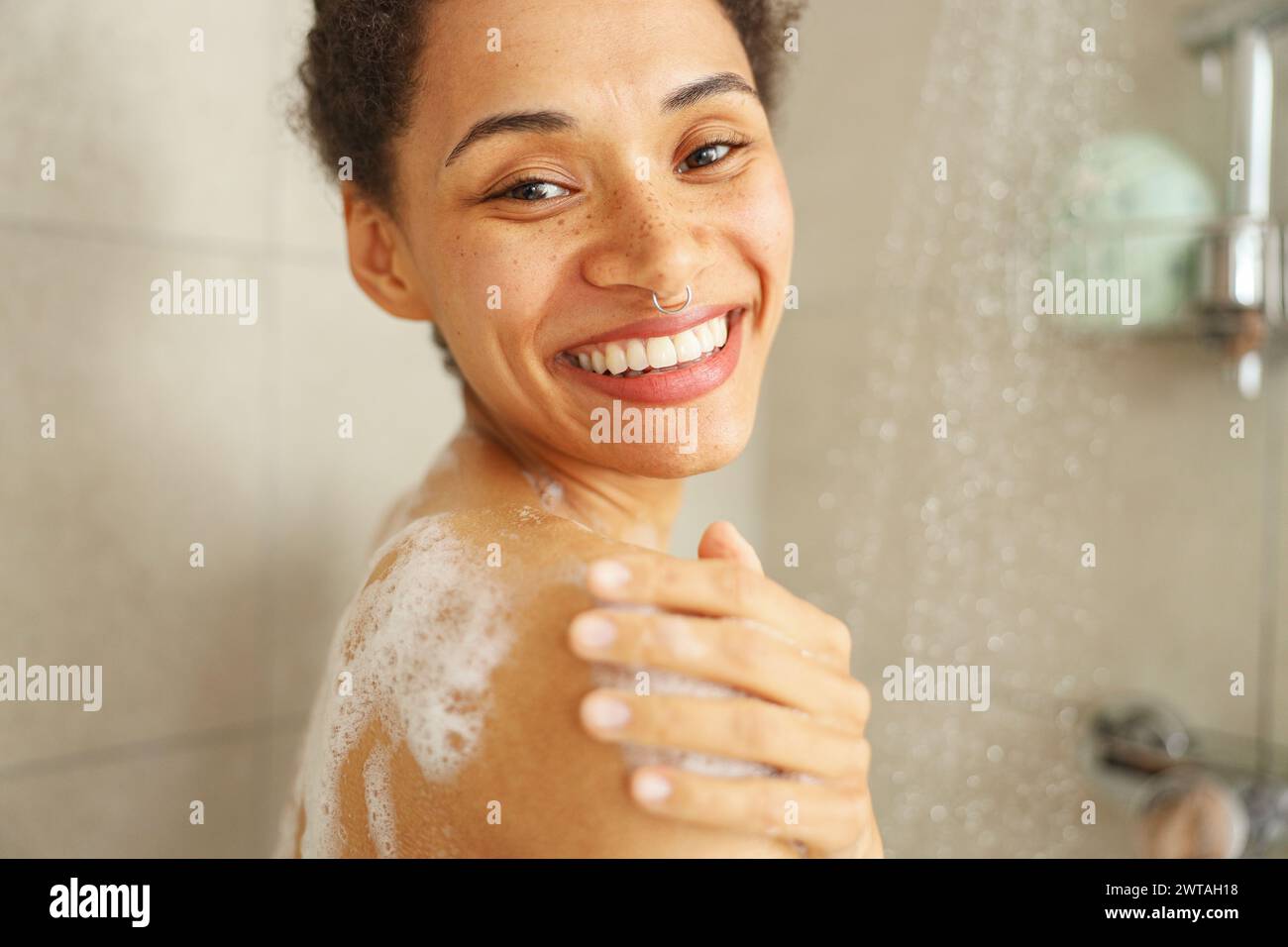 A Woman Happily Showers Smiling As She Washes Her Face Hair And Body