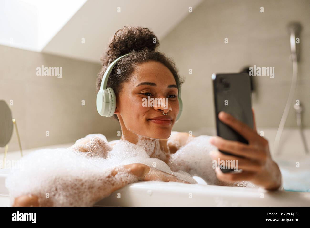 She hand gestures soap onto her back, cleansing every curve with care ...