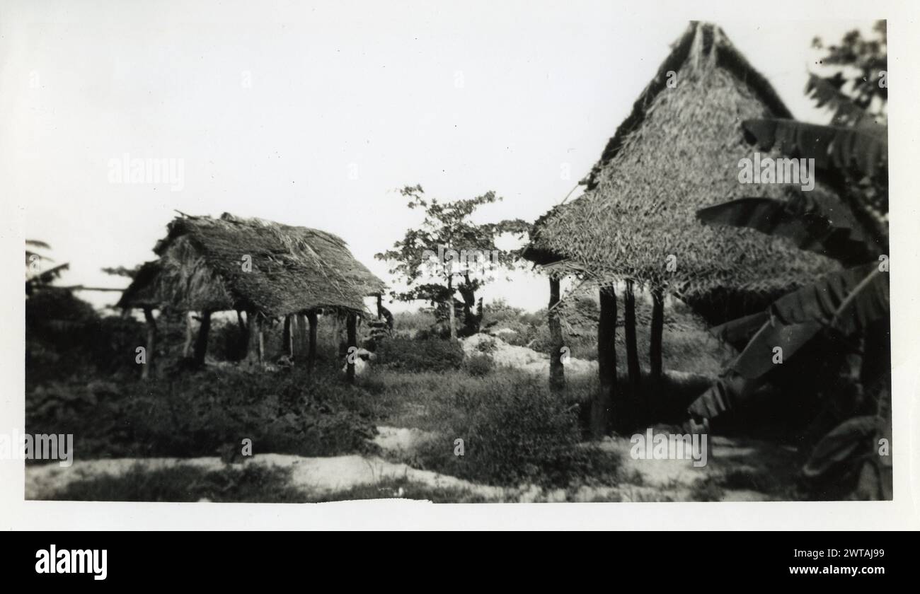 Thatched roof structures somewhere in the Pacific Ocean region circa ...