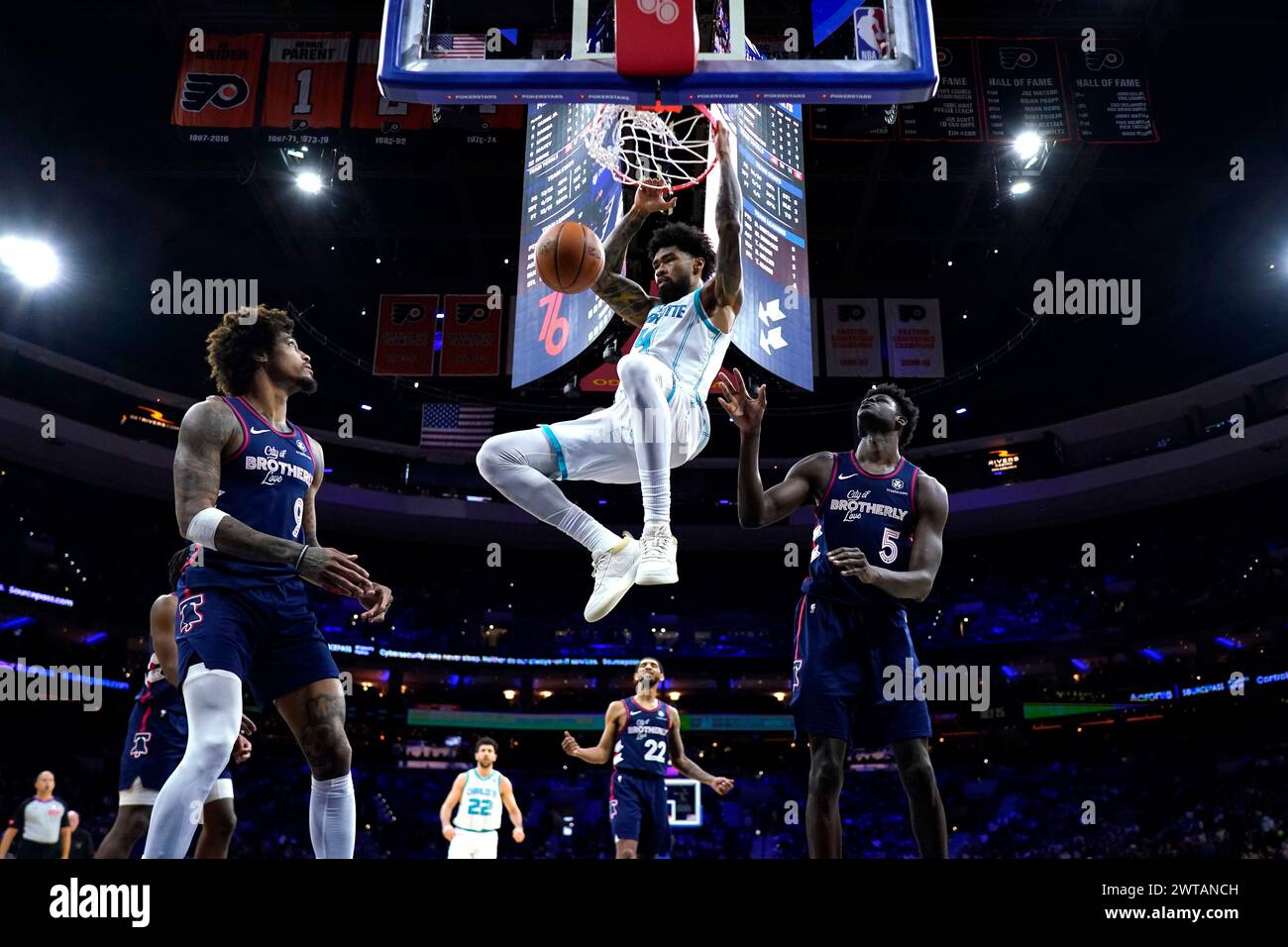 Charlotte Hornets' Nick Richards, center, dunks between Philadelphia ...