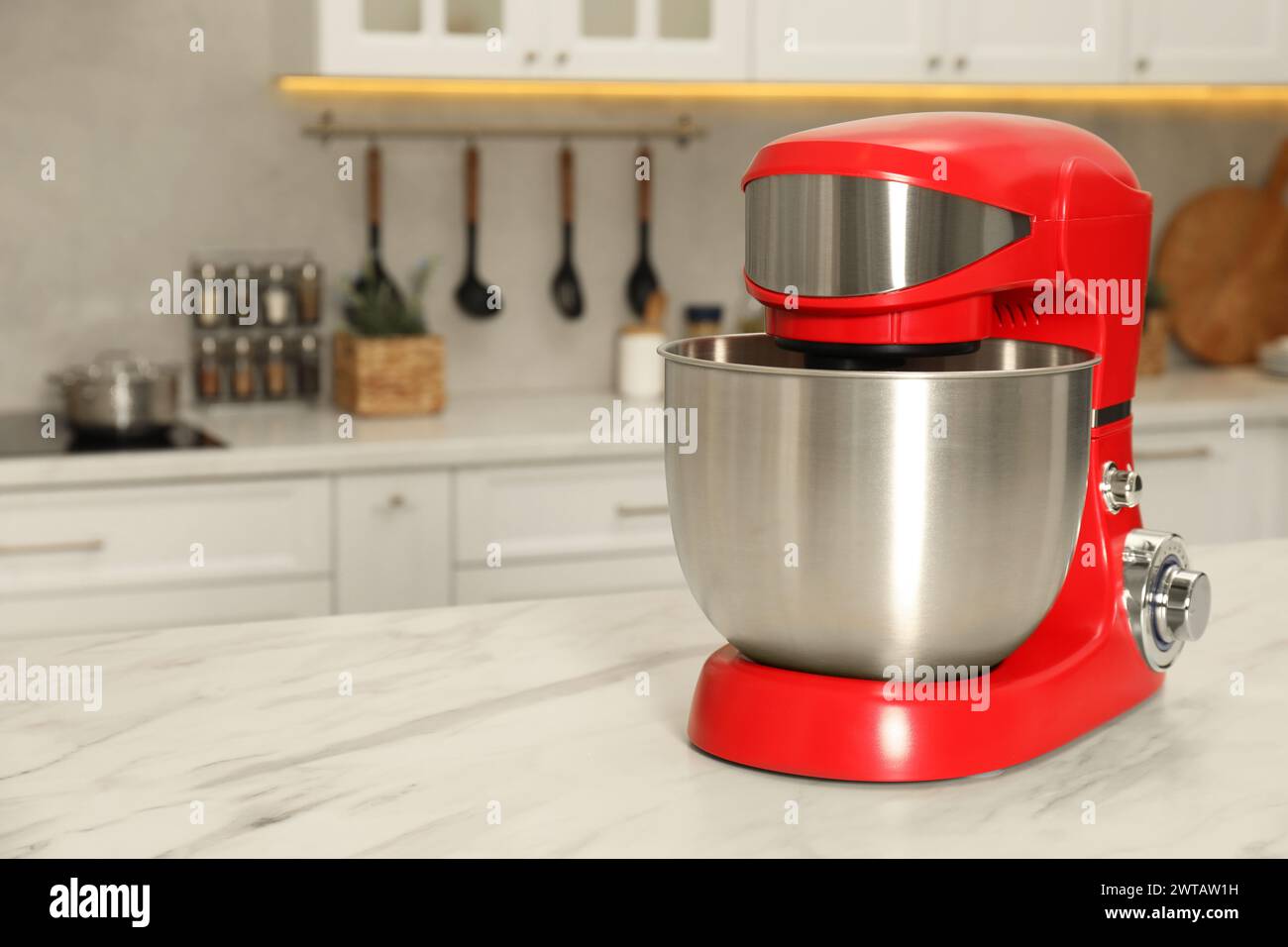 Modern red stand mixer on white marble table in kitchen, space for text ...