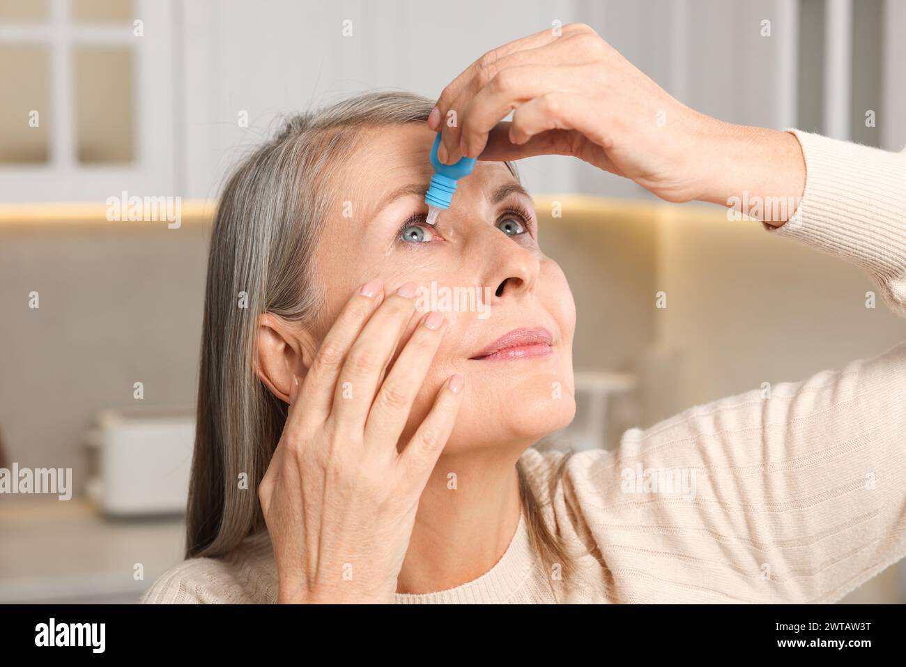 Woman applying medical eye drops at home Stock Photo - Alamy