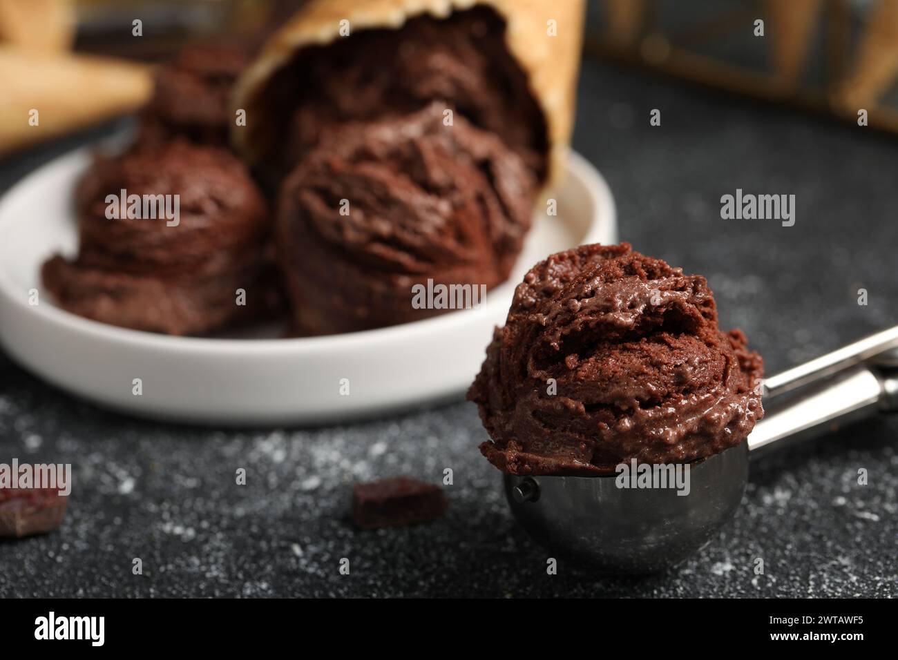 Tasty ice cream scoops and waffle cones on dark textured table, closeup ...