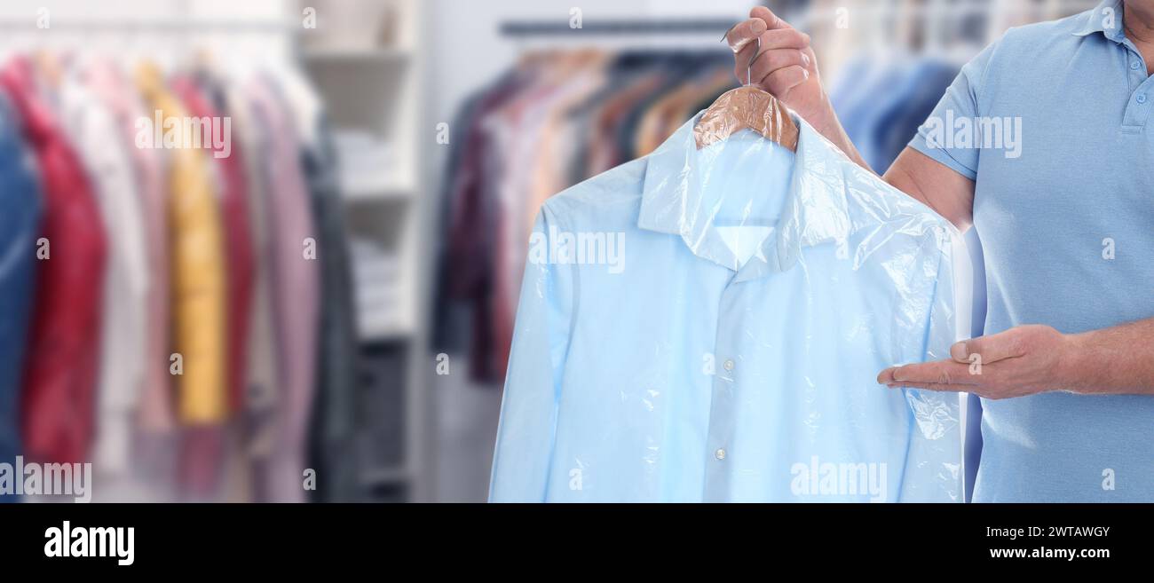 Dry-cleaning service. Man holding hanger with shirt in plastic bag ...