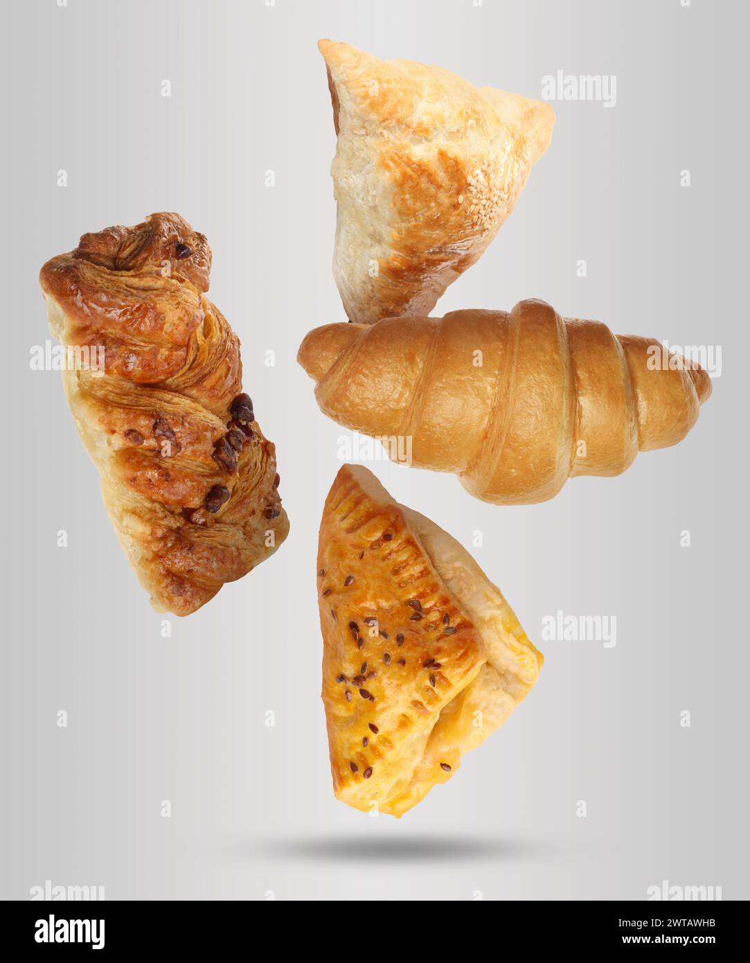 Different tasty puff pastries falling on light grey background Stock ...