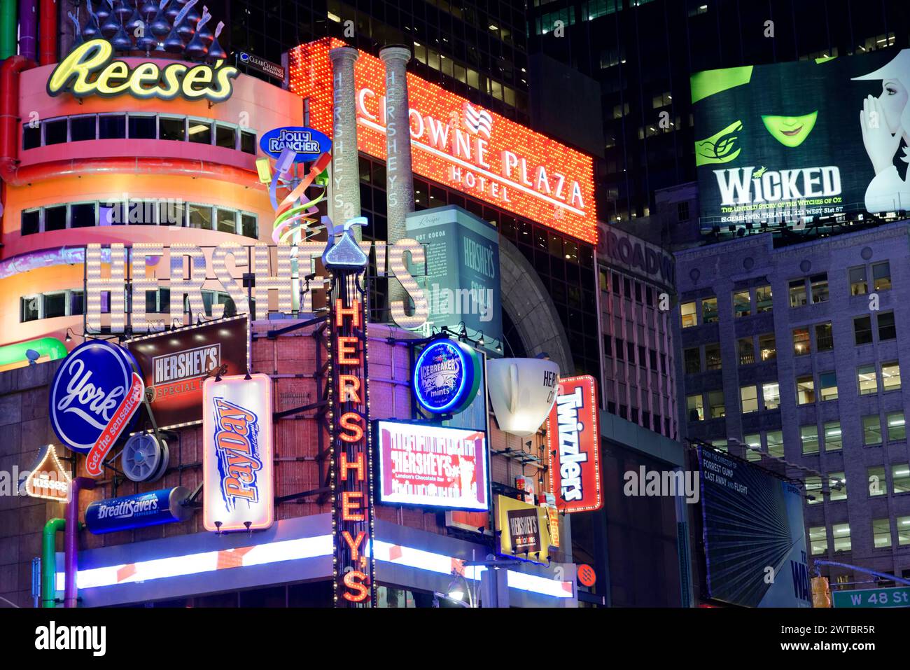 Illuminated billboards and neon lights on a busy city street at night ...