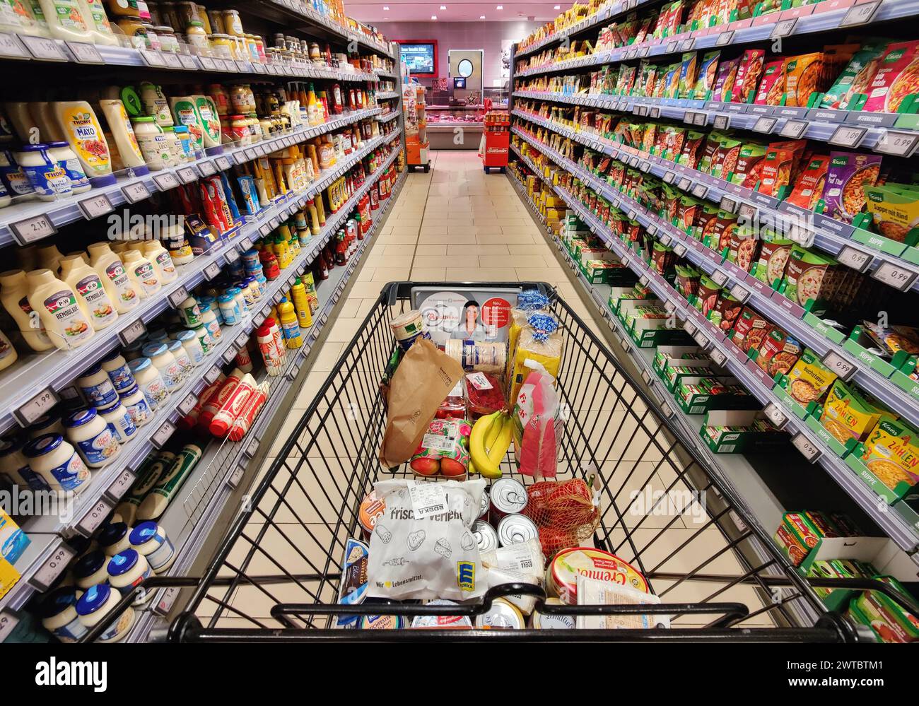 Shopping trolley being pushed through an aisle, supermarket, Witten ...
