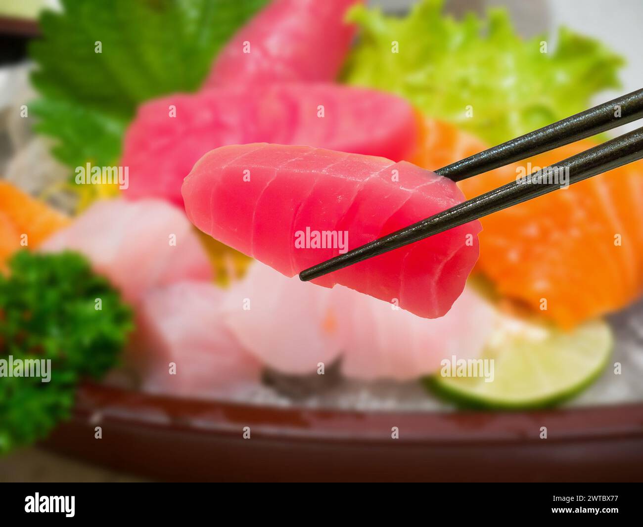red tuna fish slice sashimi in chopsticks with tuna, salmon sashimi set ...