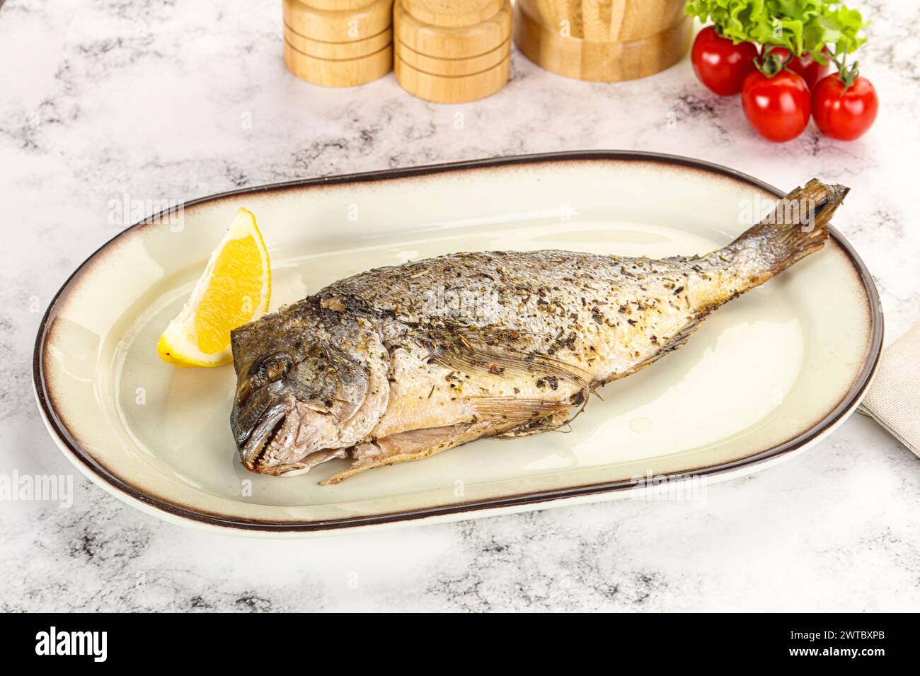 Baked Dorado fish served lemon slice Stock Photo - Alamy