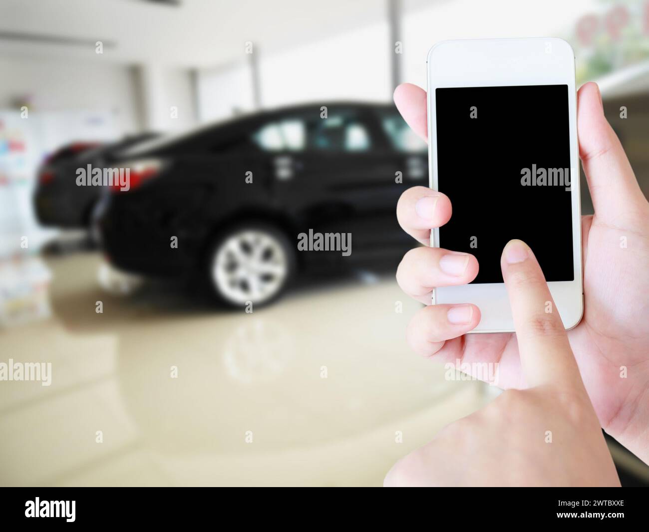 woman hands holding mobile phone with blurred background of new cars in ...