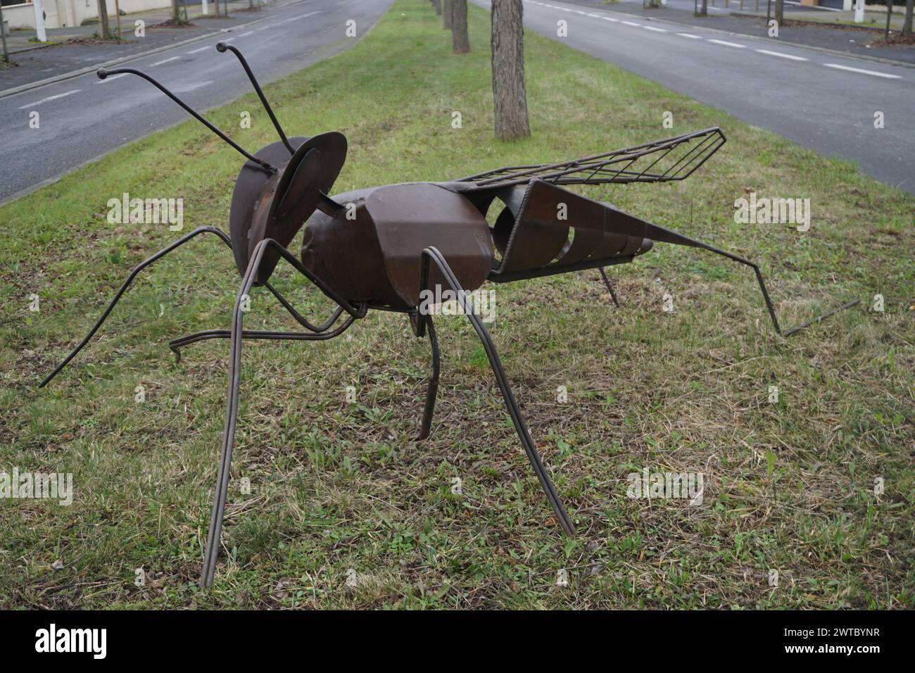 metal sculpture of a giant ant on the lawn by the roads in the country ...