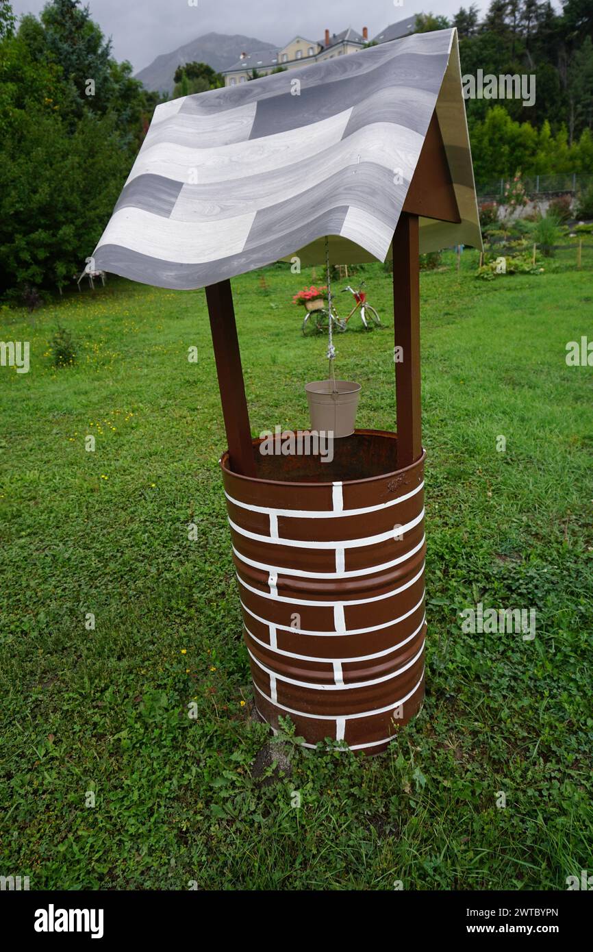 closeup on a fake painted well in the garden in the alps, france Stock ...