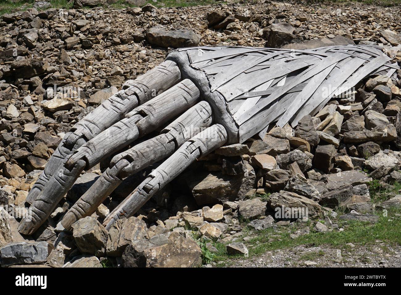 closeup on a giant wooden hand resting on the rocky landscape in the ...