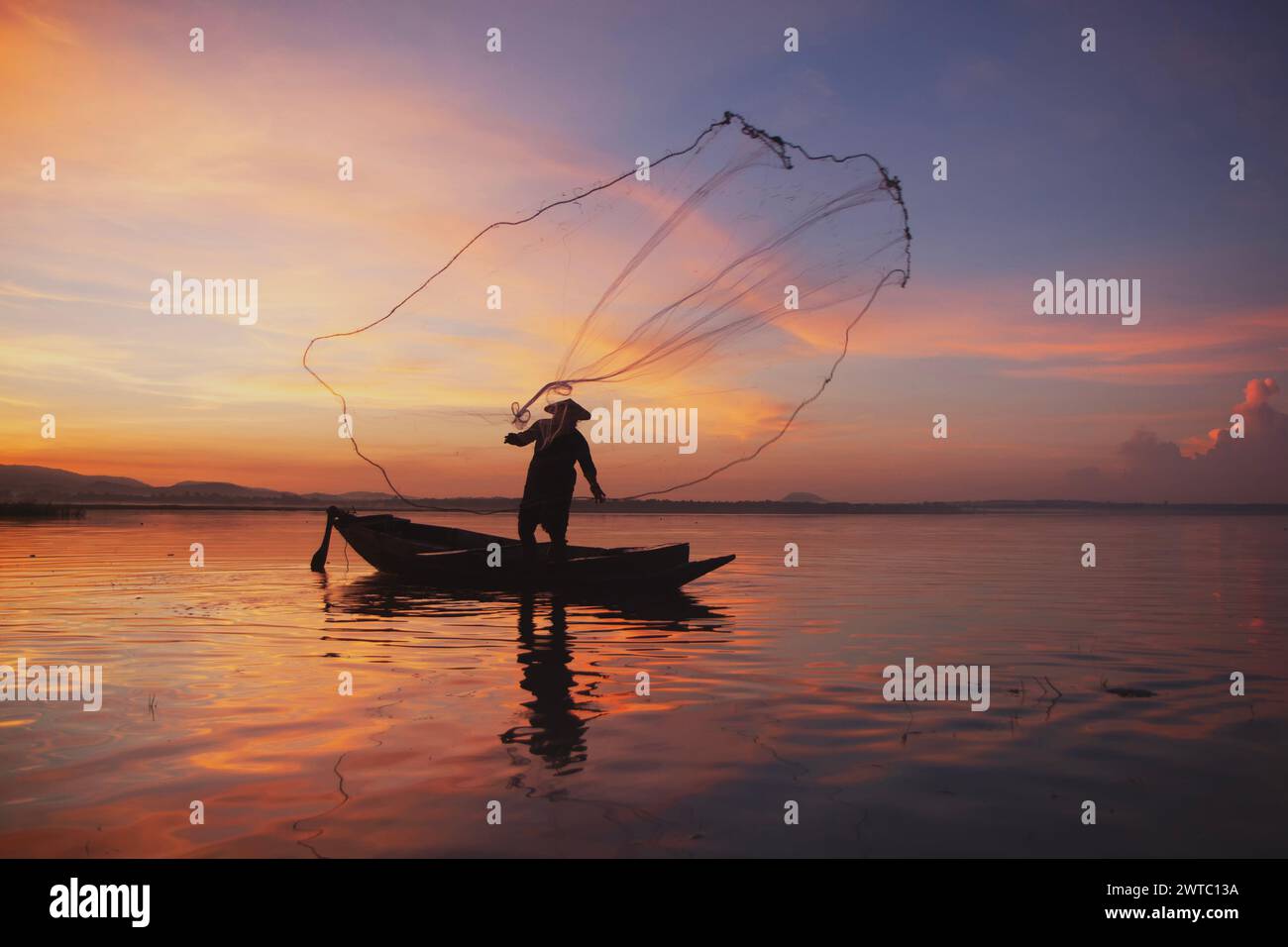 Fisherman casting his net on during sunset. Silhouette Asian fisherman ...