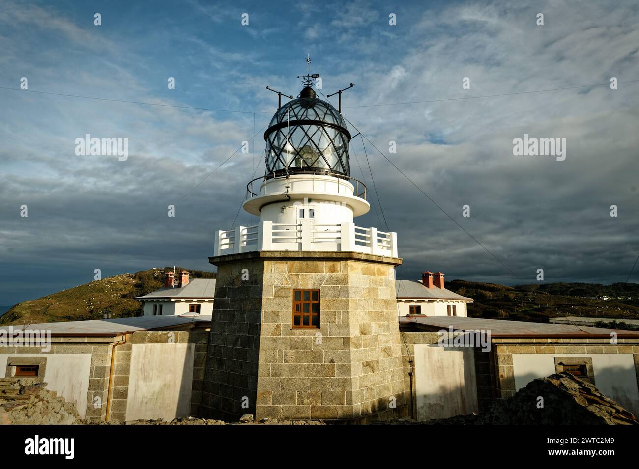 A lighthouse tower featuring windows and a roof with dual white trims ...