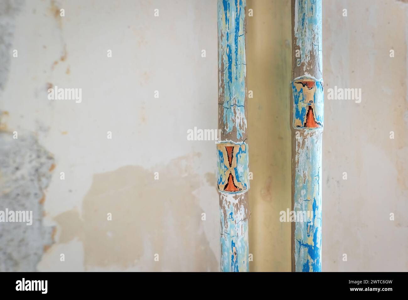 Old sanded copper heating plumbing pipes over plastered wall in england ...