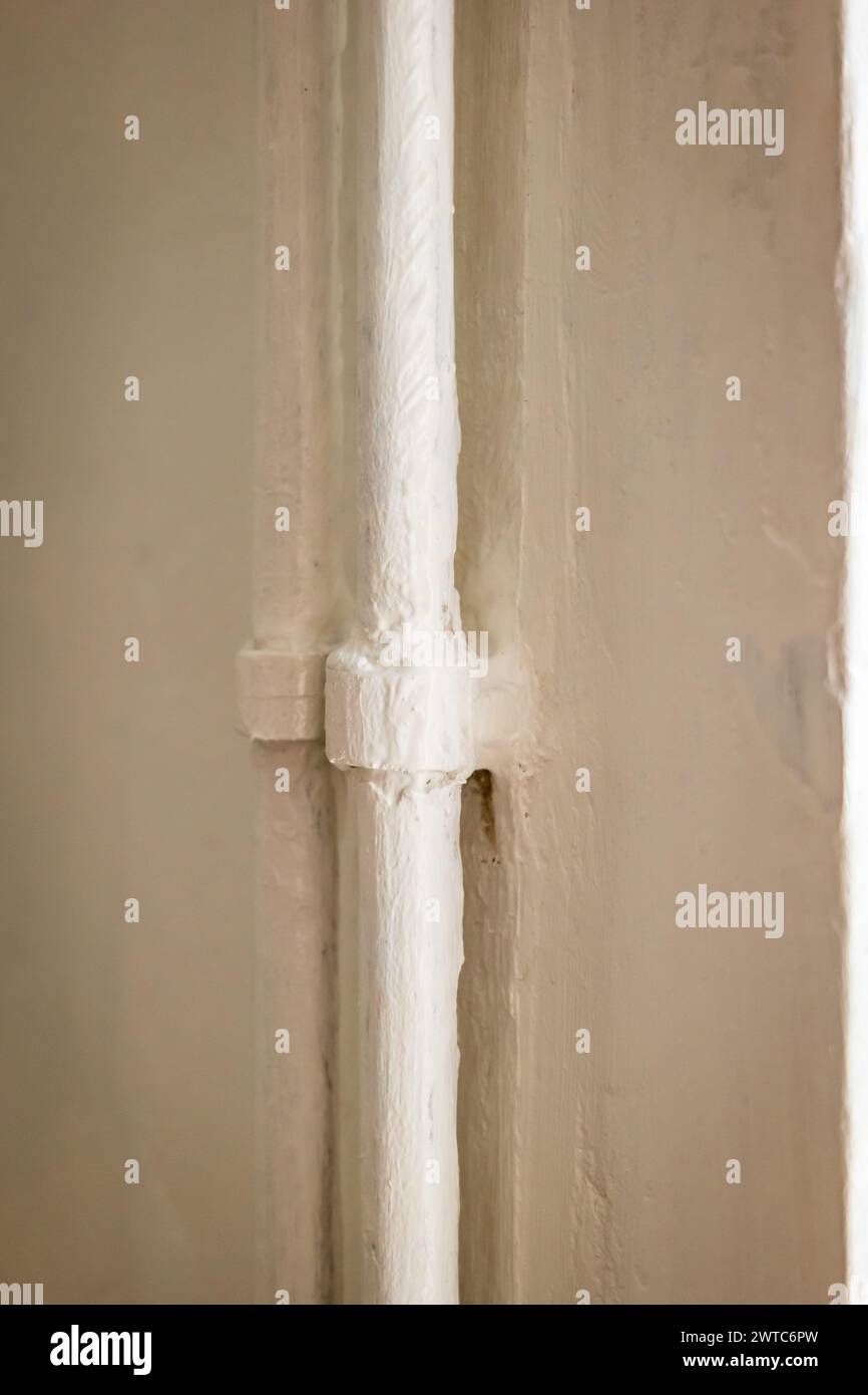 Old painted copper heating plumbing pipes over plastered wall in ...