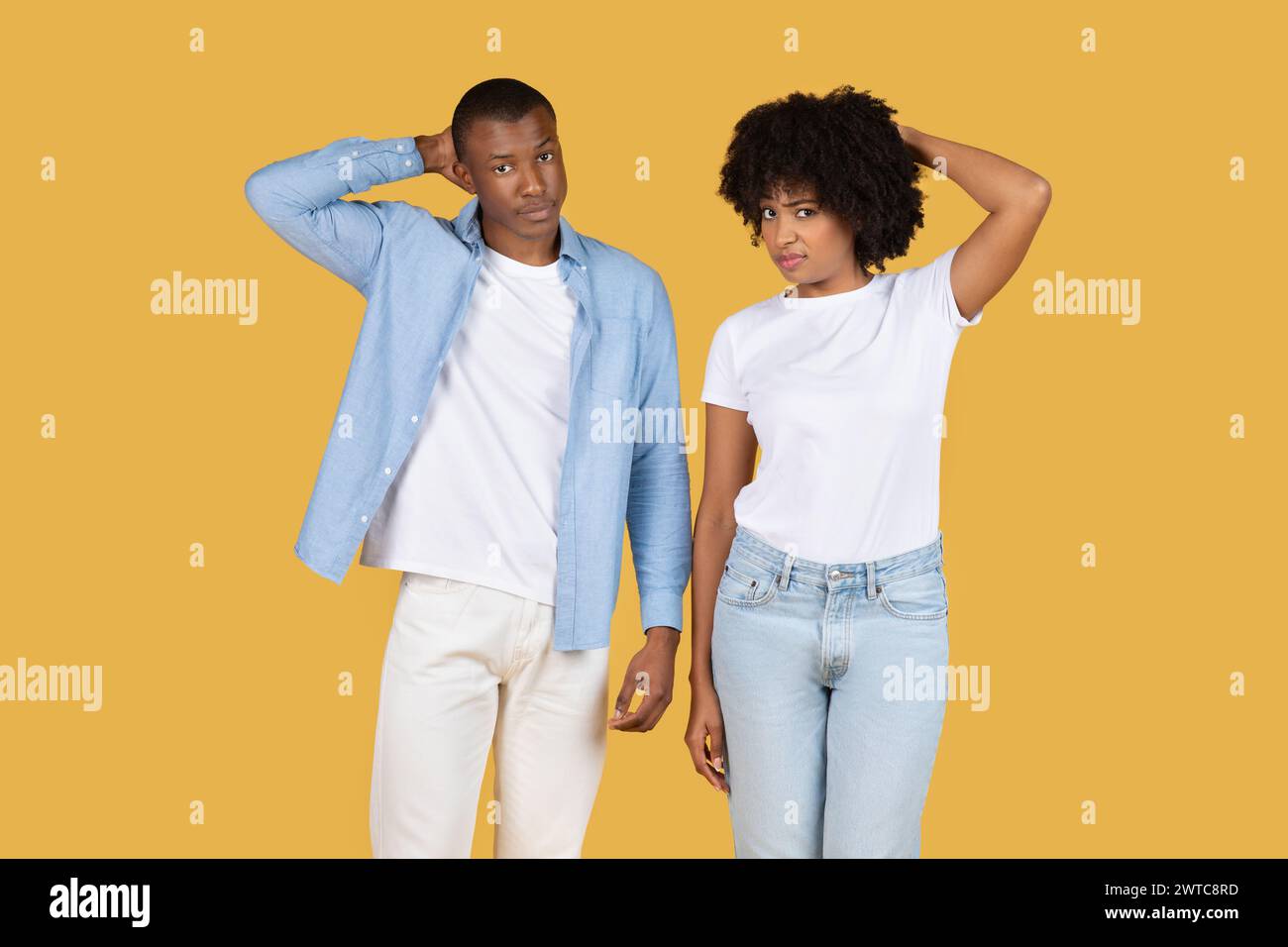 Two puzzled young adults in casual attire with a quizzical expression ...