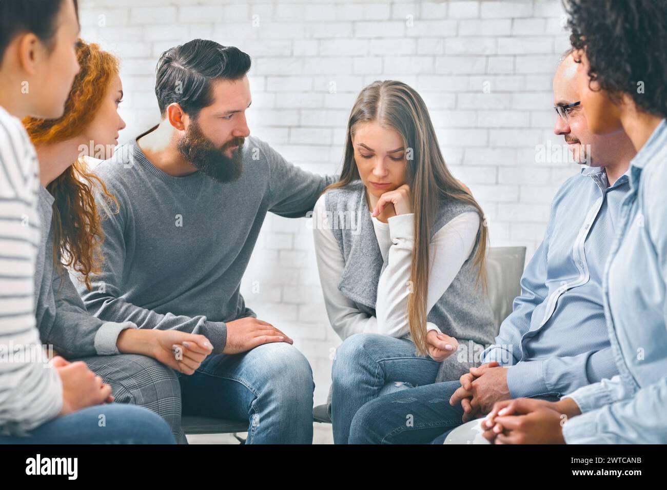 Concerned patients comforting depressed woman in rehab group Stock ...
