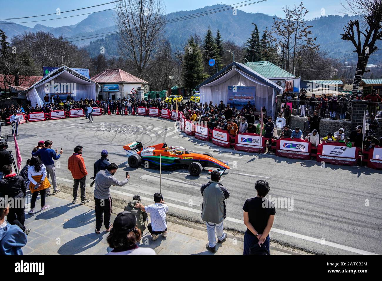 People watch a car participating in a Formula-4 race organized to boost adventure tourism in the ...