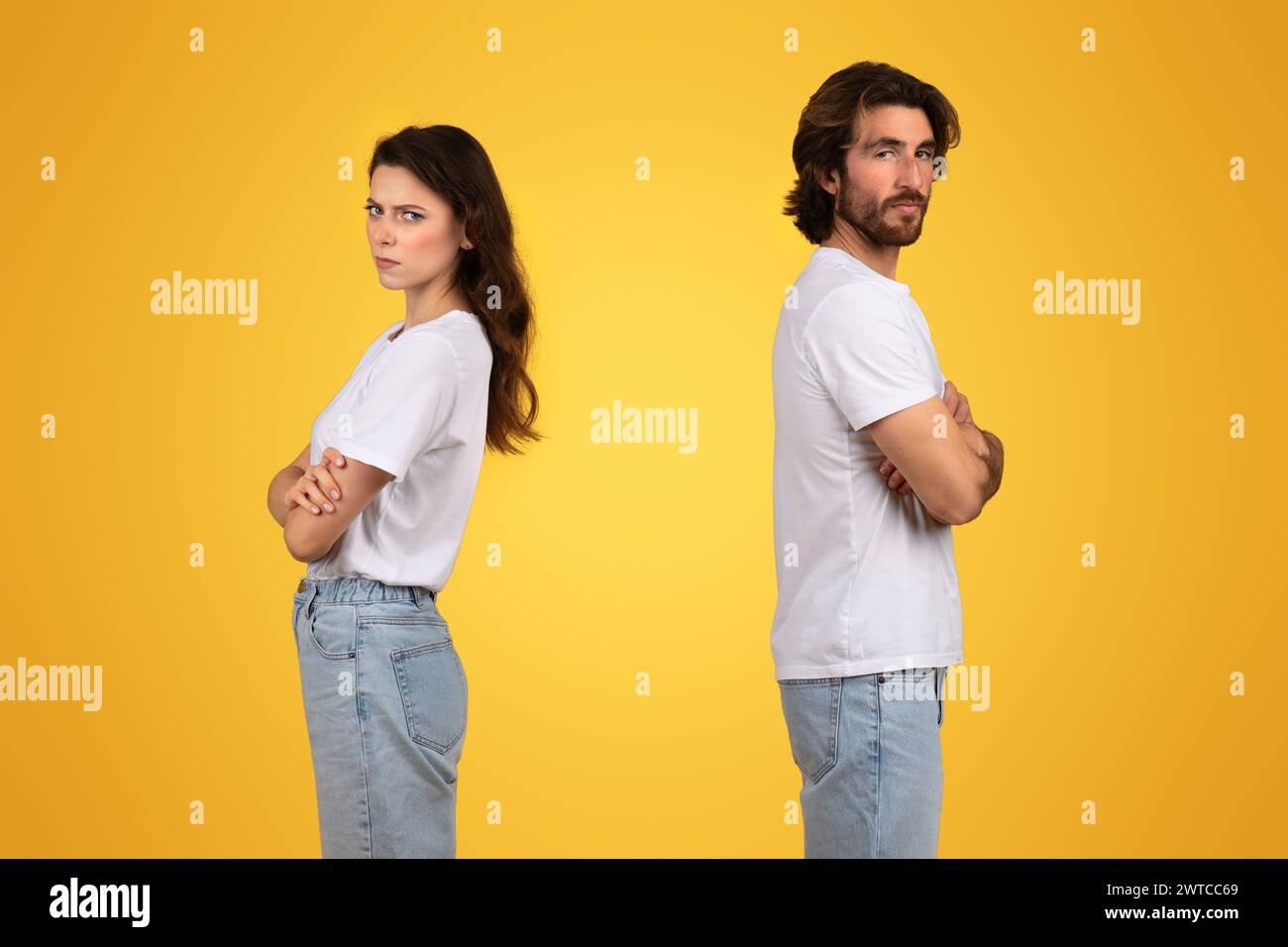 Upset man and woman standing back-to-back with arms crossed, showing ...