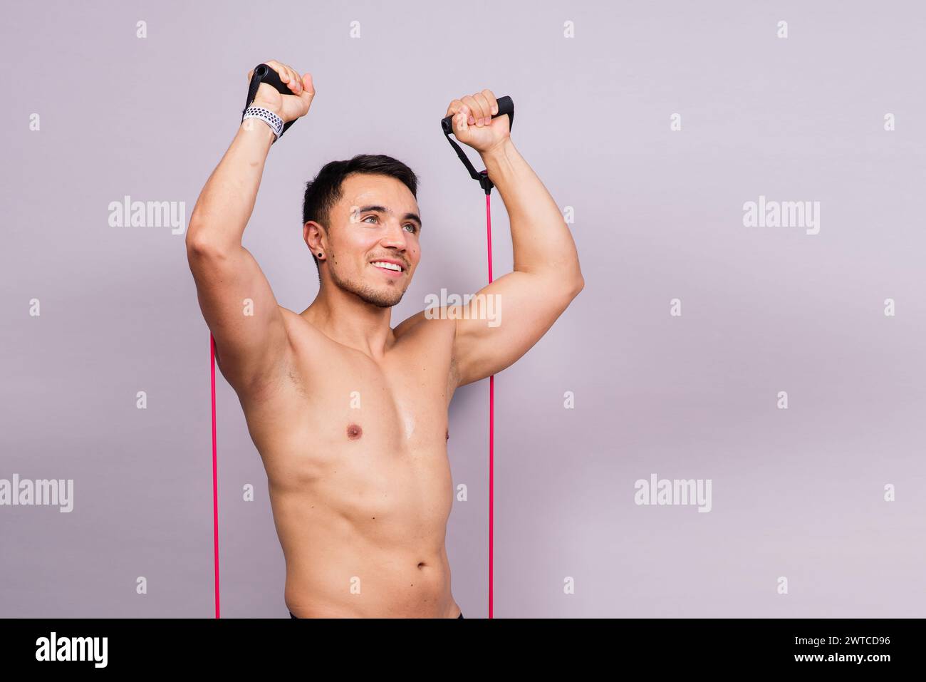 Young handsome man during workout with a resistance rubber bands ...