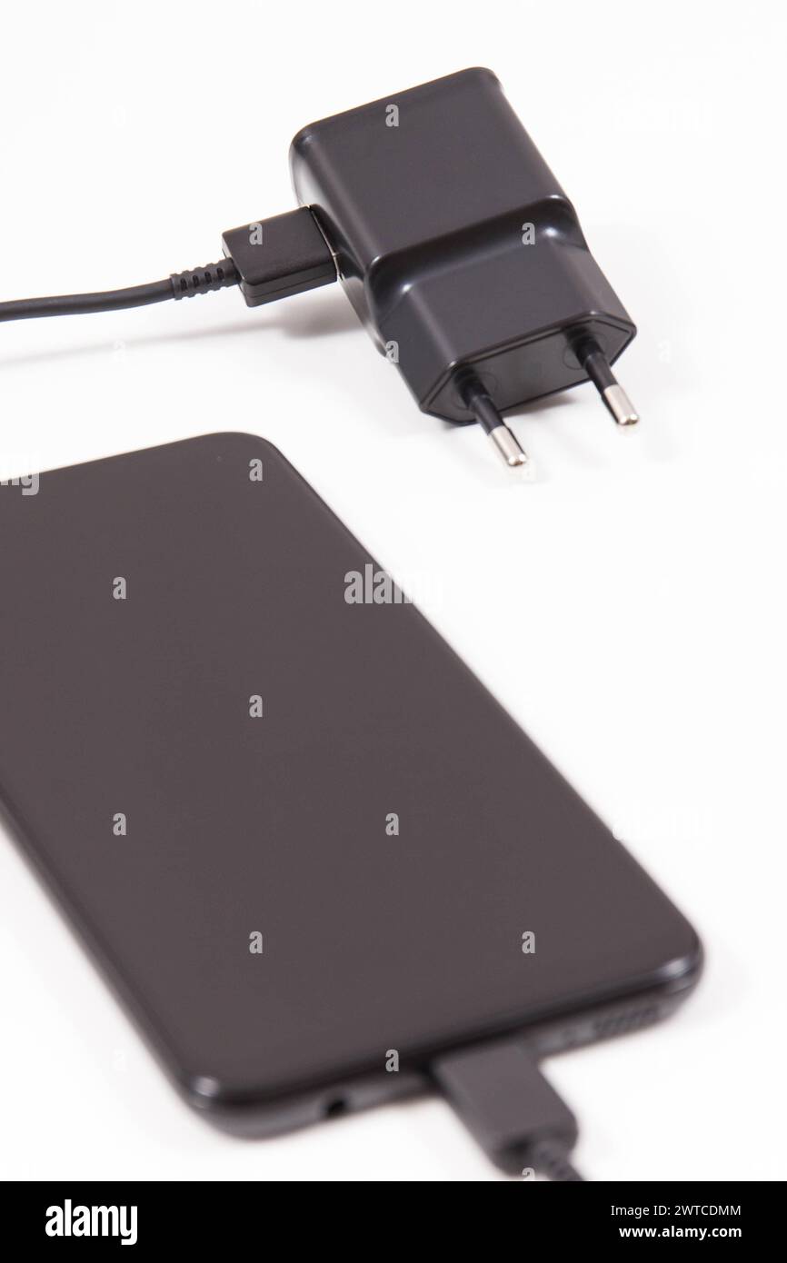 Mobile phone with connected plug of charger. Smartphone charging. White ...