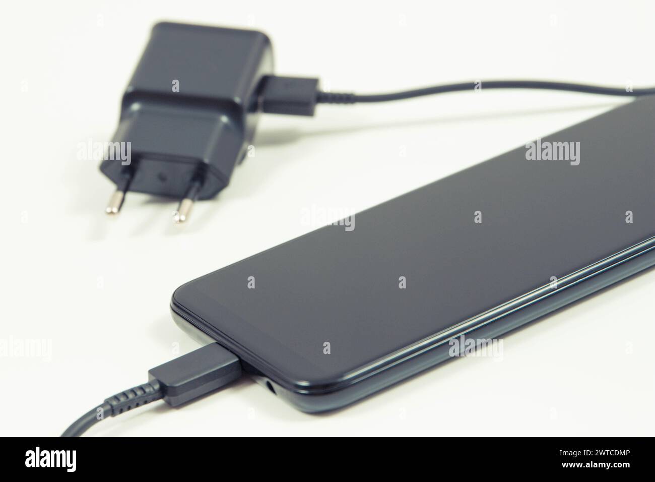 Smartphone with connected plug of charger. Telephone charging. White ...