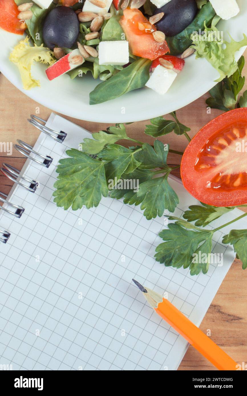 Fresh prepared greek salad with feta cheese and notepad with tape ...