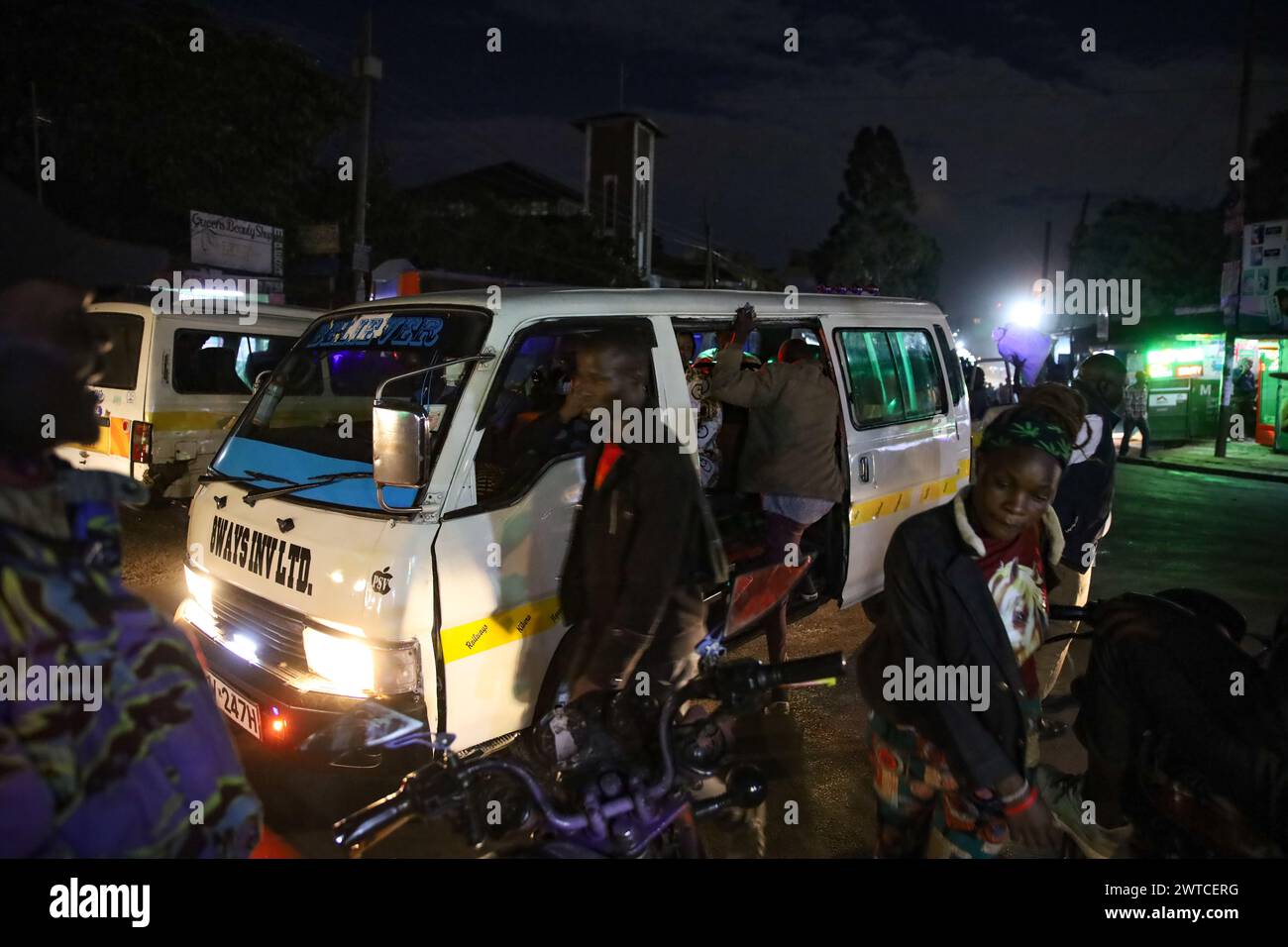 A mini van drops commuters at a bus stop in Kibera Slum, Nairobi ...