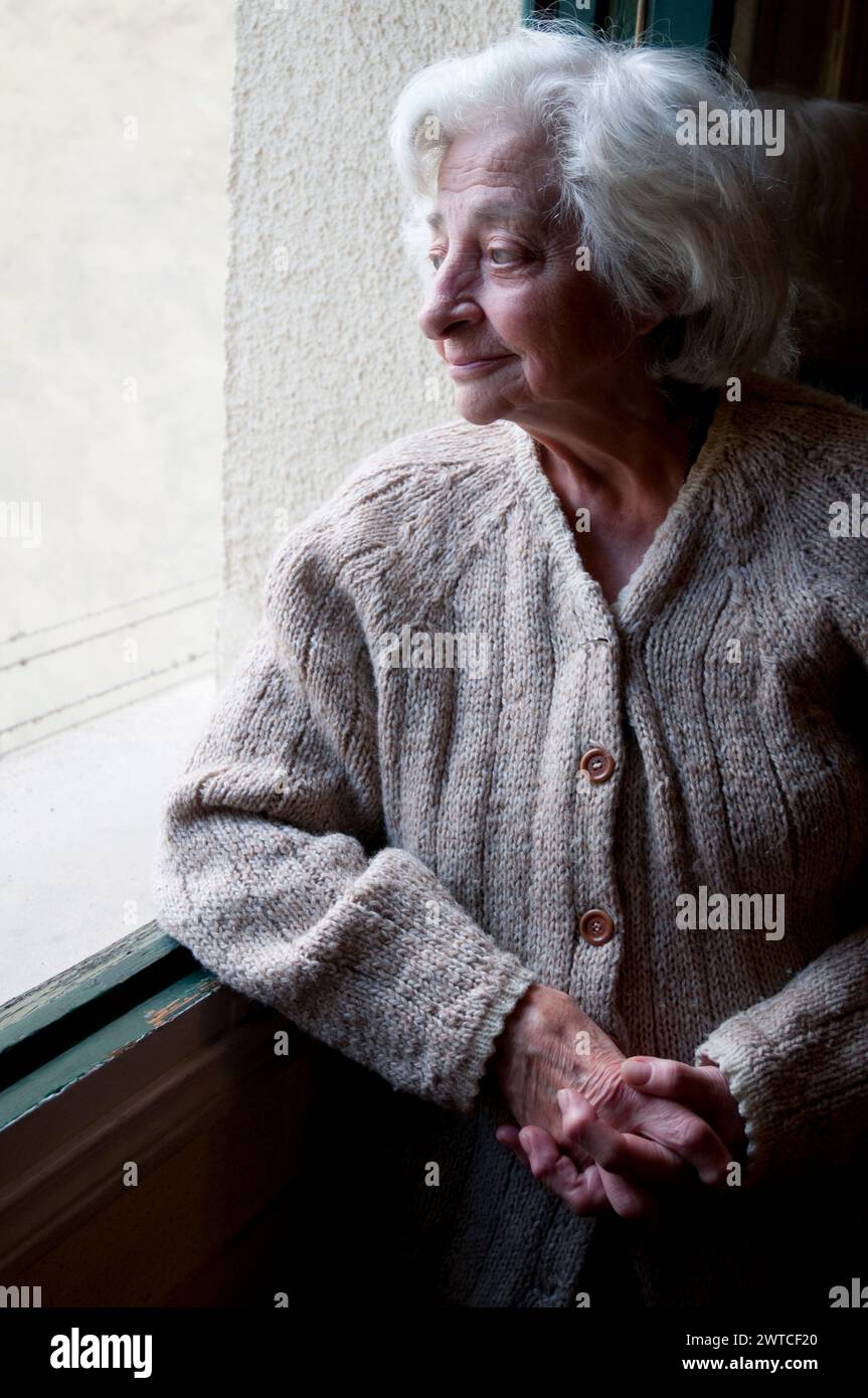 Old woman looking through the window Stock Photo - Alamy