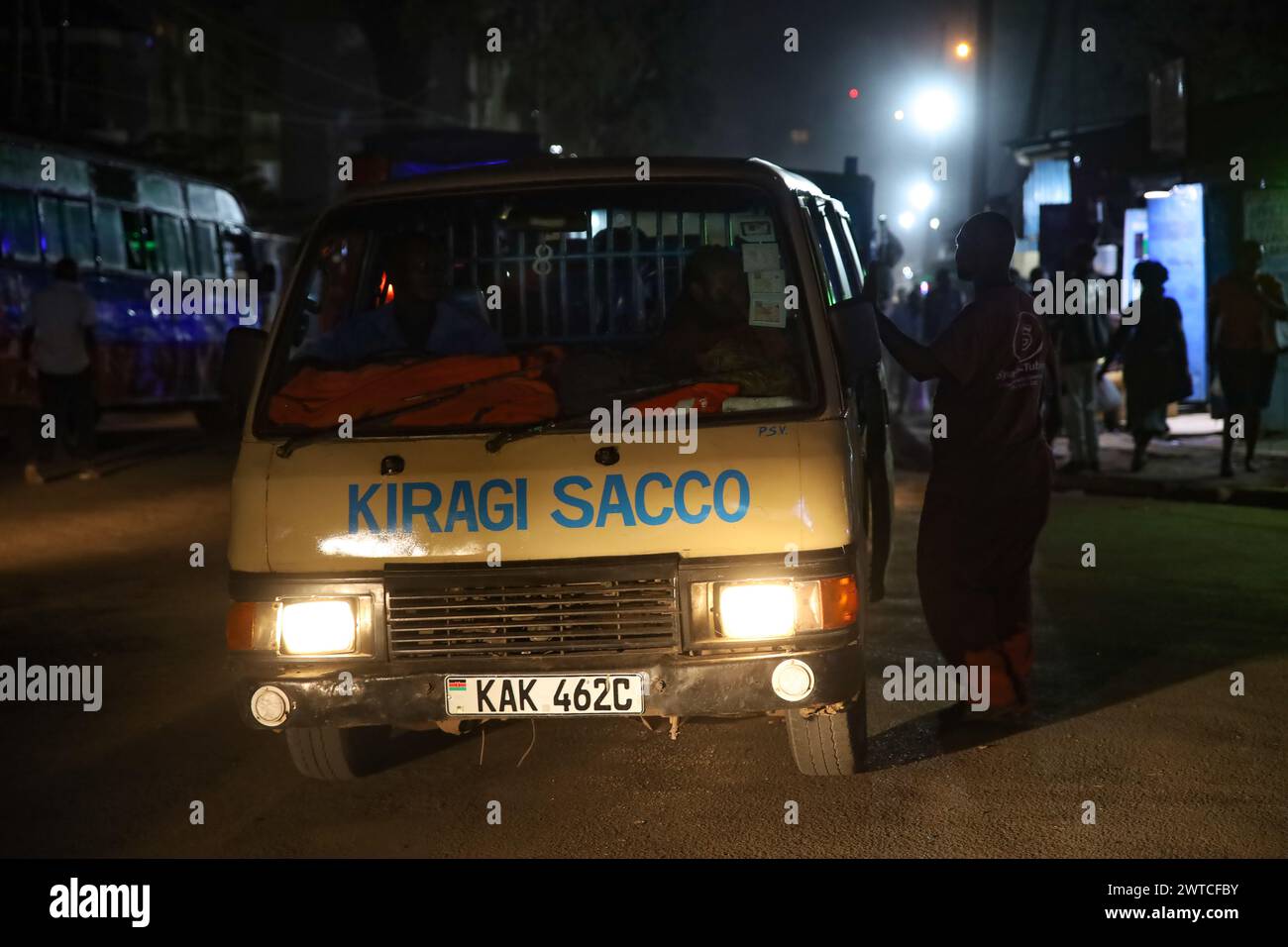 A mini van drops commuters at a bus stop in Kibera Slum, Nairobi ...