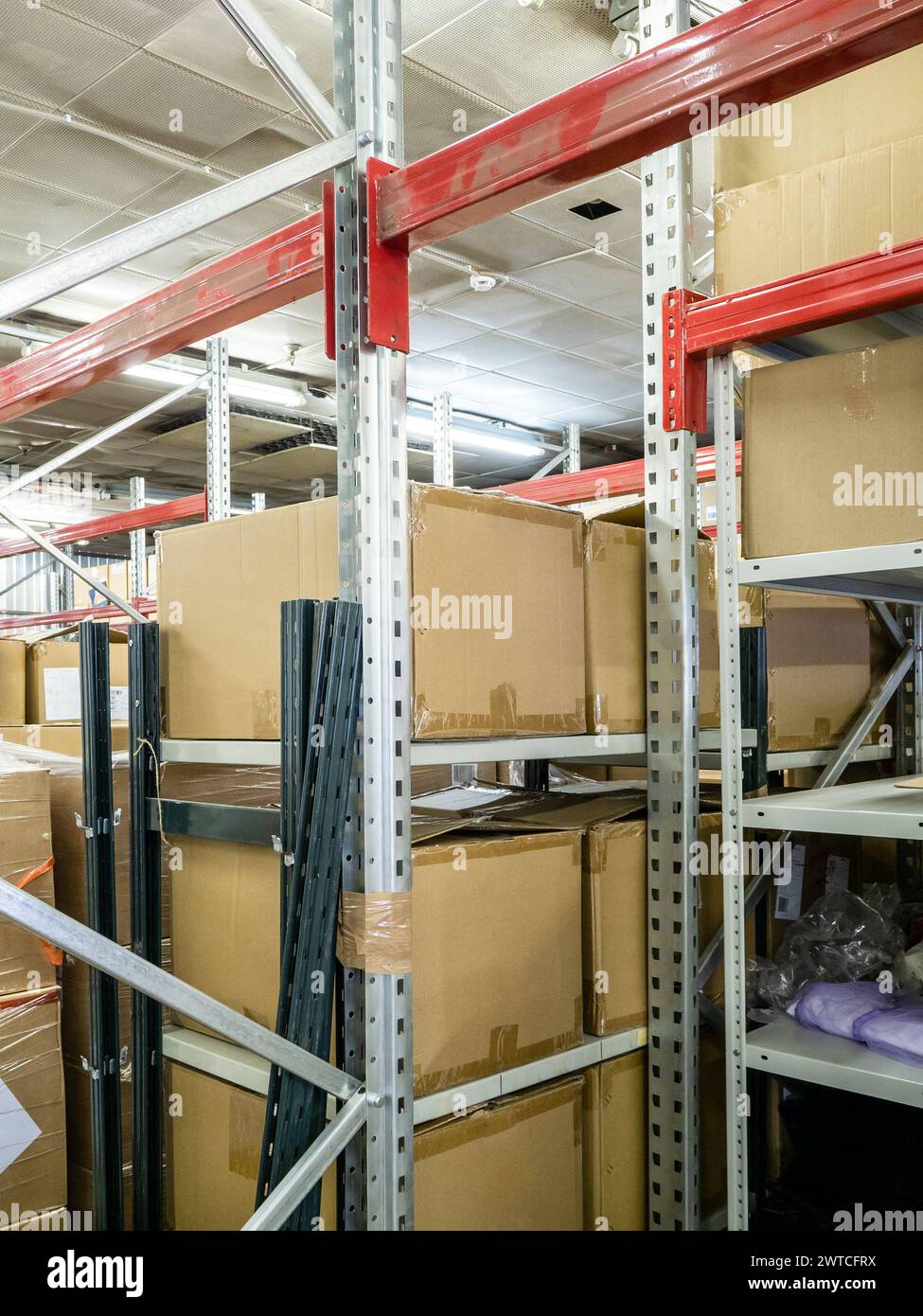 cardboard boxes on racks in warehouse illuminated by electric light ...