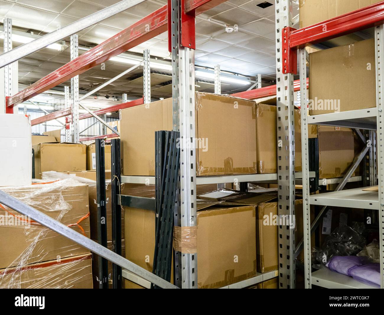 cardboard boxes on racks in storeroom illuminated by electric light ...