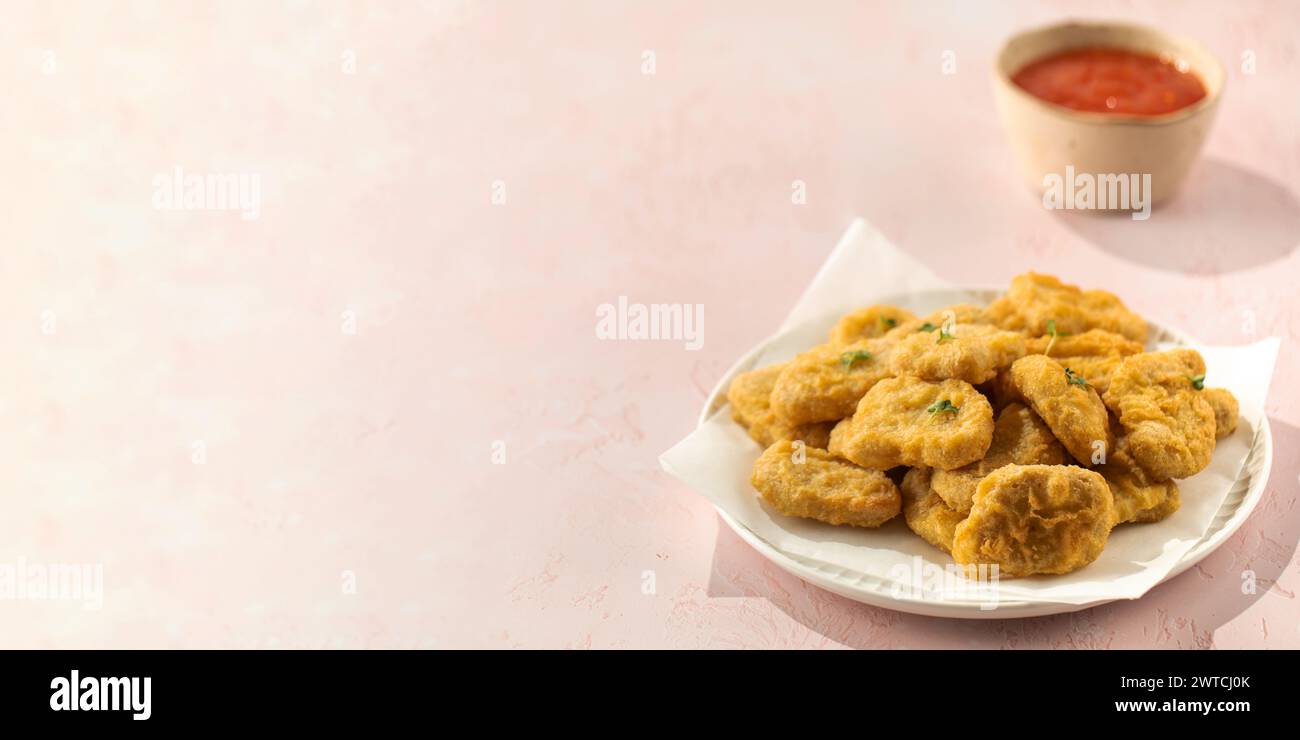 Delicious golden chicken nuggets on a plate on the table. Fast food ...