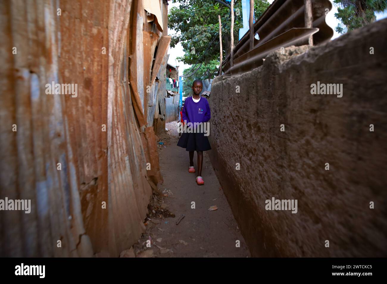 A girl walks past the corridors in Kibera Slum. Kibera, the largest ...
