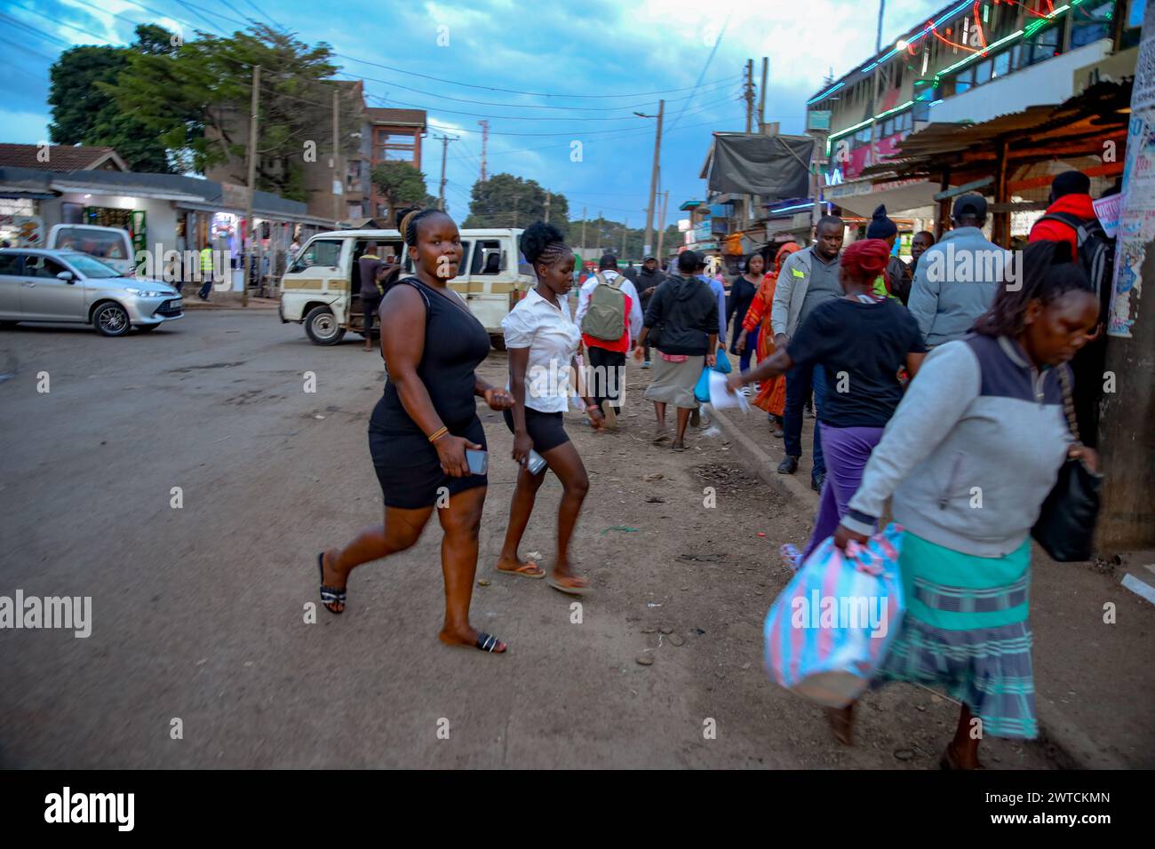 Residents walk past the busy streets in Kibera Slum headed for their ...