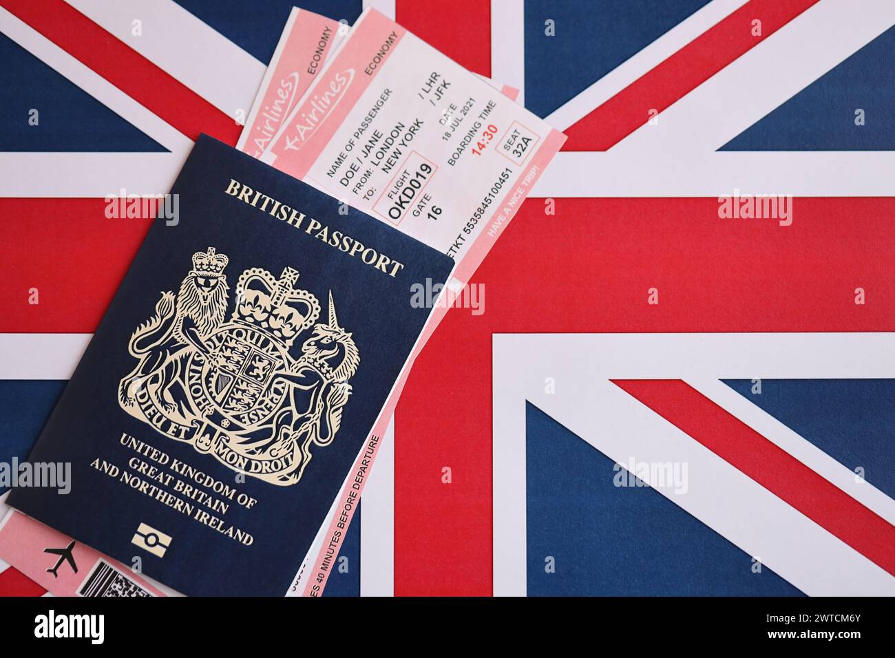 Blue British passport with airline tickets on national flag background ...