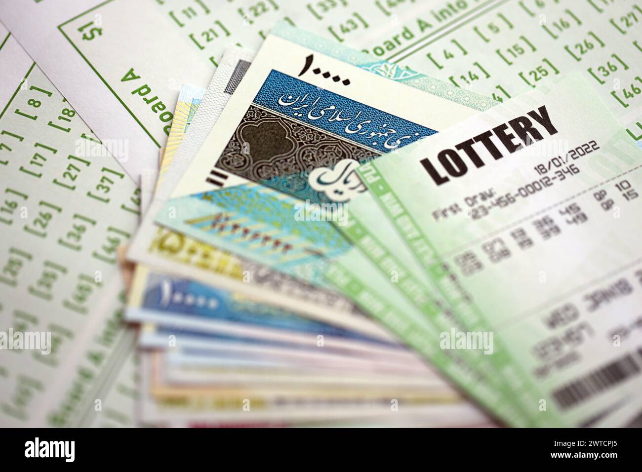 Green lottery tickets and iranian money bills on blank with numbers for ...