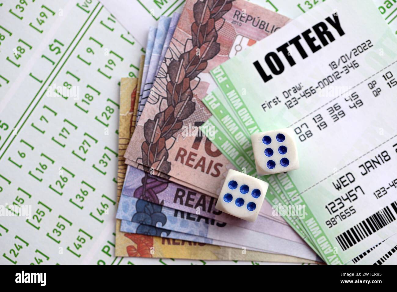 Green lottery tickets and brazilian reals money bills on blank with ...