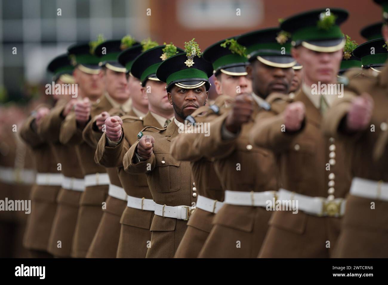 Irish Guardsmen, wearing a sprig of shamrock in their hats, offered as ...