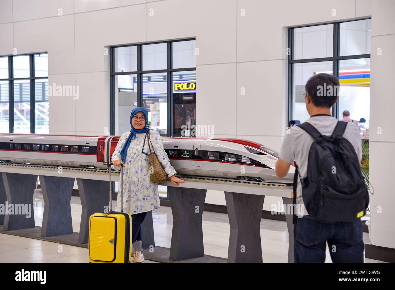 Jakarta, Indonesia. 17th Mar, 2024. A passenger poses for photos with a model of a high-speed ...