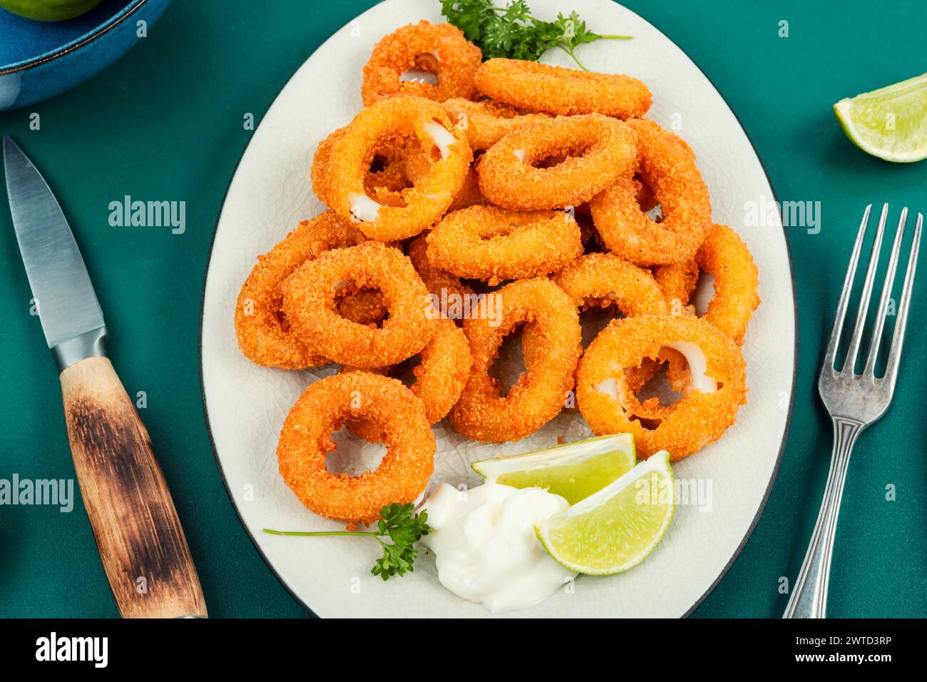 Baked breaded calamari rings served with lime Stock Photo - Alamy