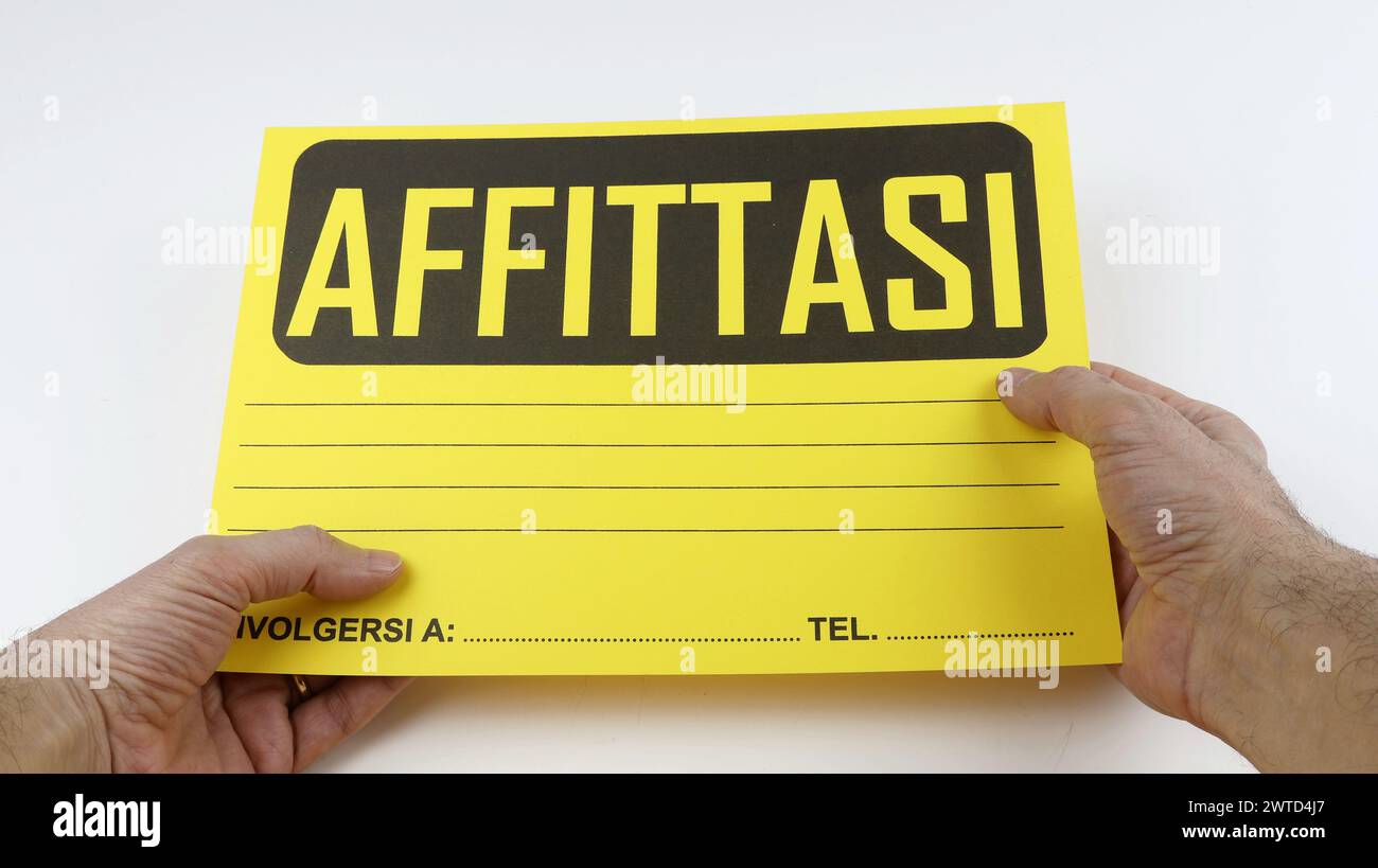 Single word RENT on language sign in italian, man's hand holds placard ...
