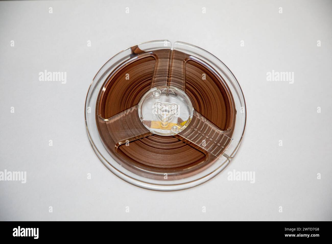 Close up on an old school audio reel to reel tape against a white ...