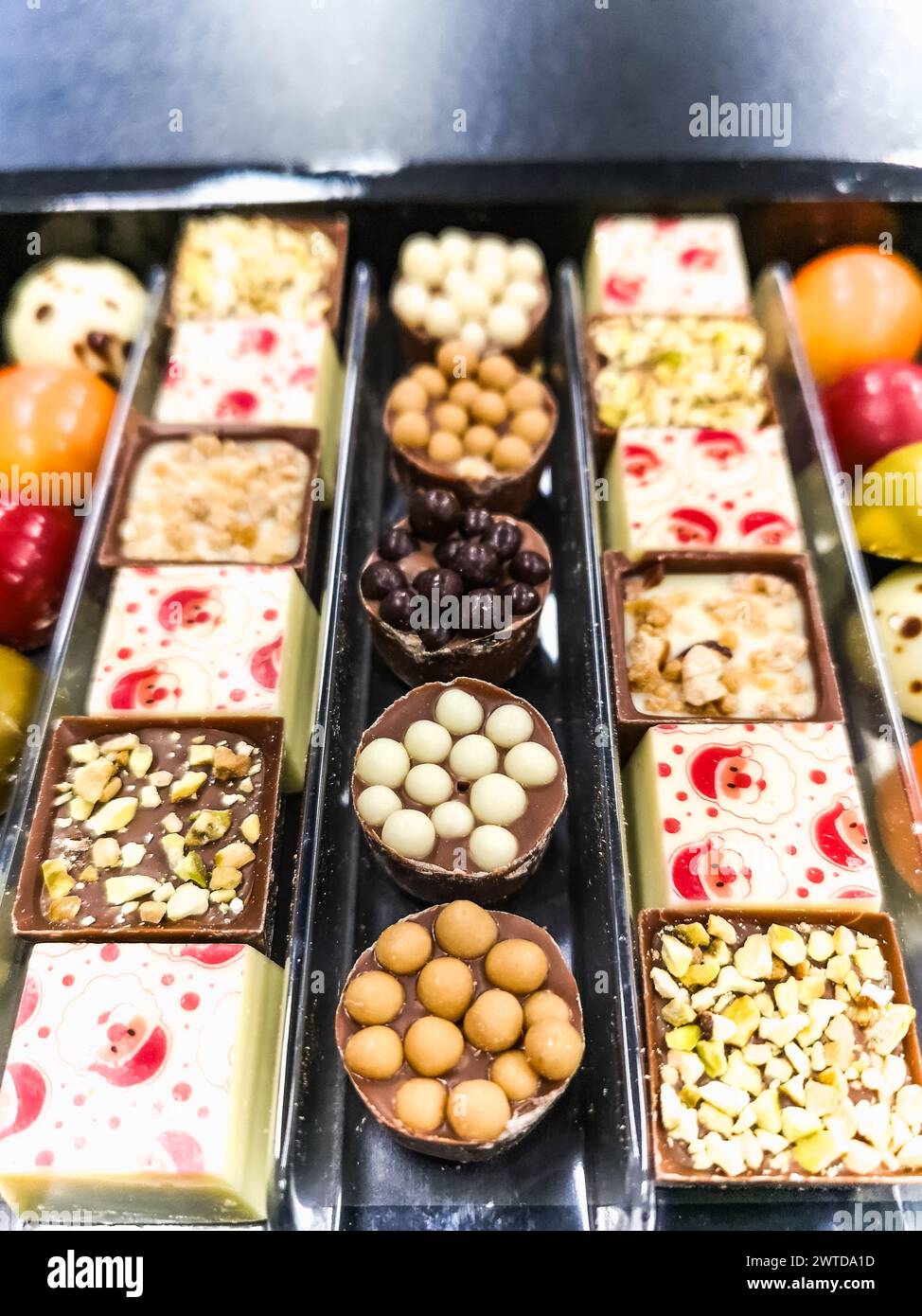 Small box of colorful and tiny chocolates with different stuffings and ...